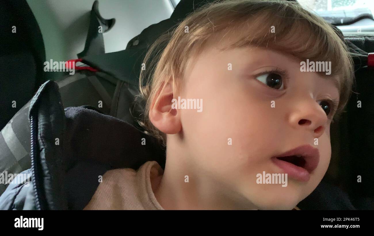 Das Baby wartet im Auto auf dem Parkplatz und ist im Babysitz ...