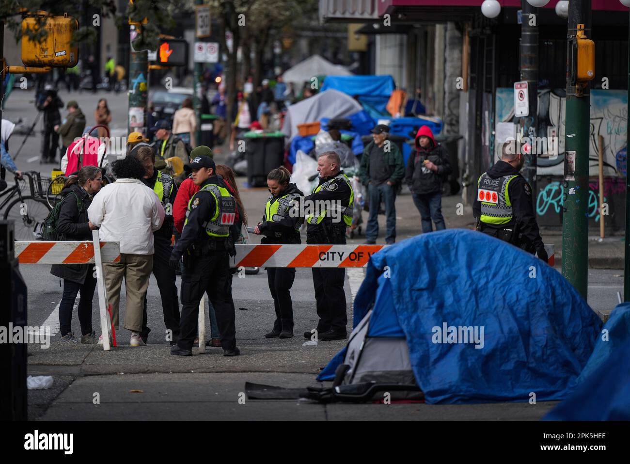 Police officers restrict access on East Hastings Street as city workers ...
