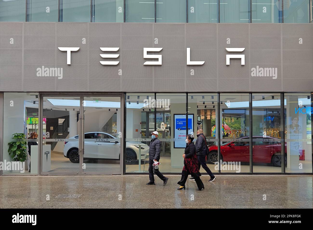 SHANGHAI, CHINA - 6. APRIL 2023 - Fußgänger gehen vorbei an EINEM TESLA ...
