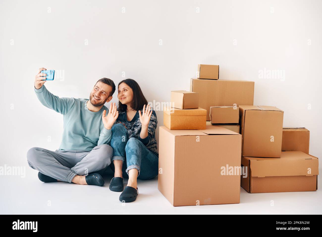 Glückliches lächelndes Paar, das Freunde bei Online-Videoanrufen mit ...