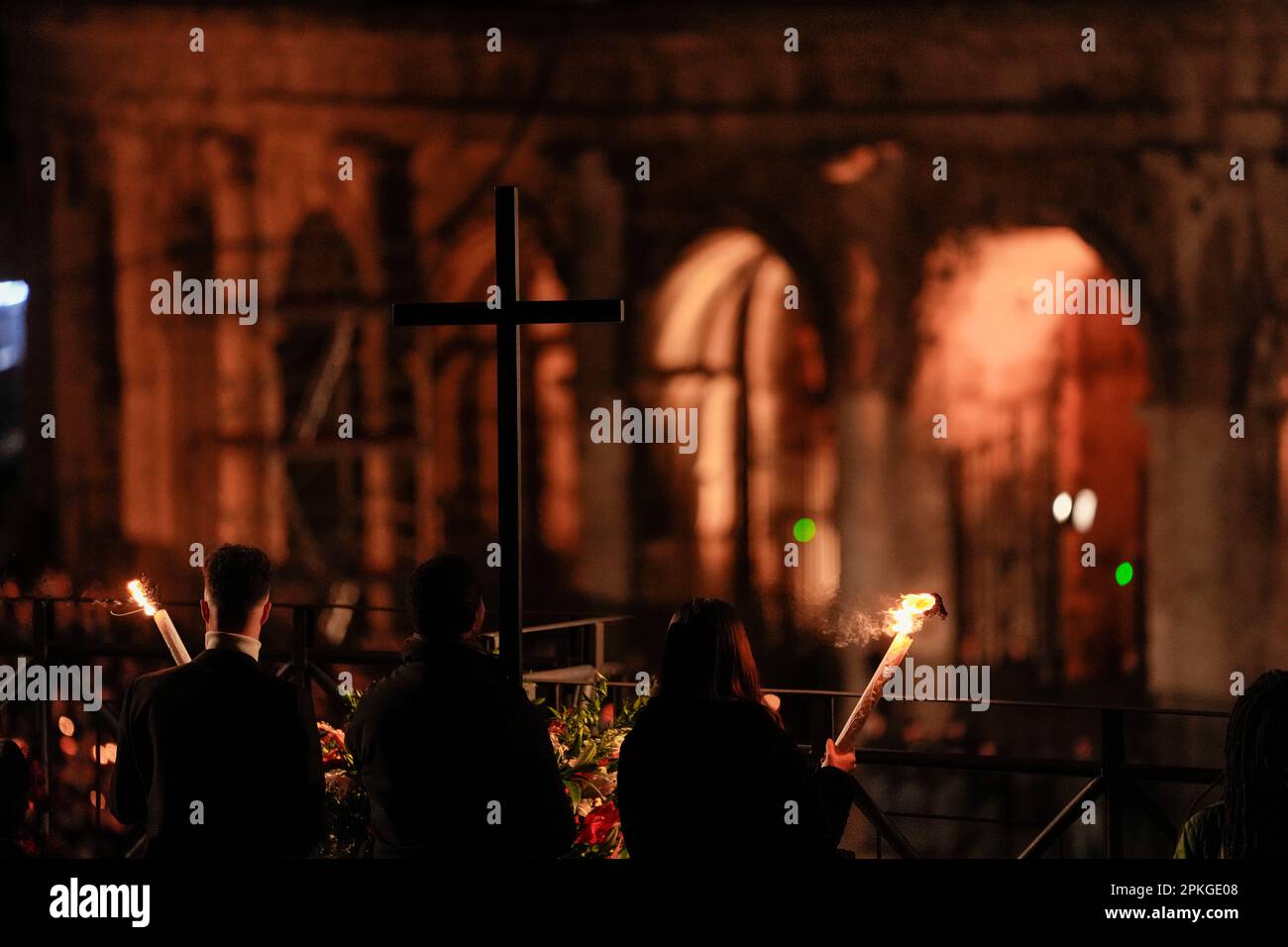 Faithful hold the cross as they take part in the Via Crucis (Way of the ...
