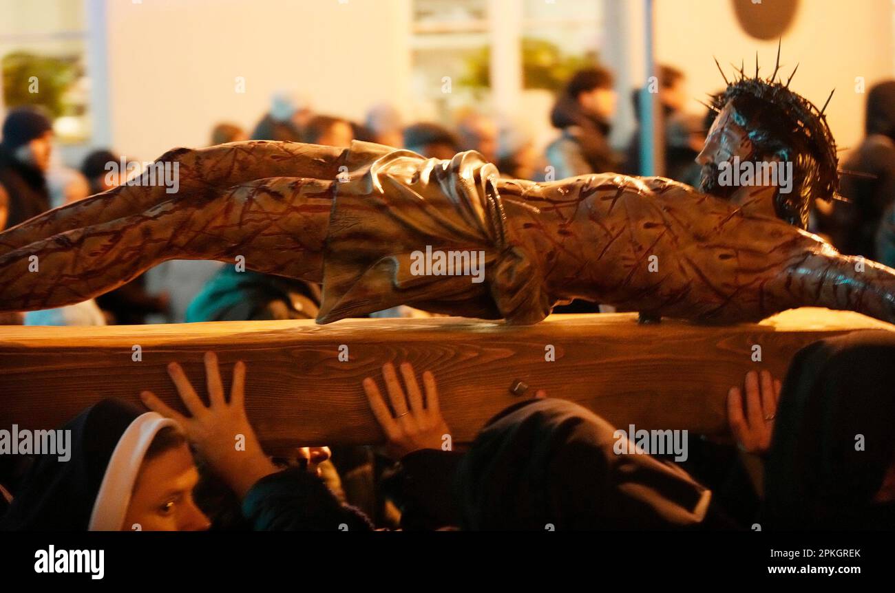 Worshippers hold a cross during a Way of the Cross procession in ...