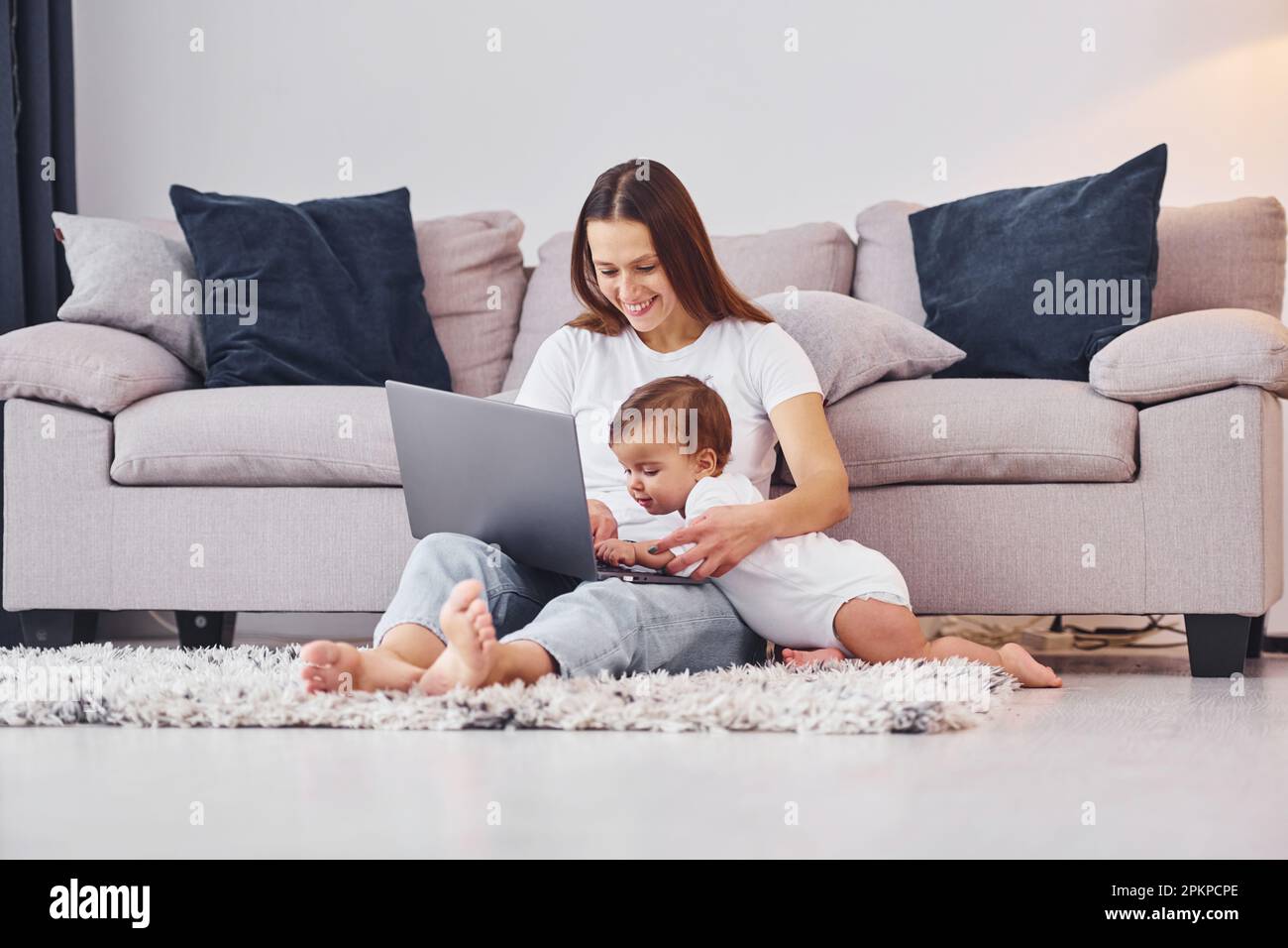 Laptop verwenden. Die Mutter mit ihrer kleinen Tochter ist zusammen zu Hause Stockfotografie - Alamy