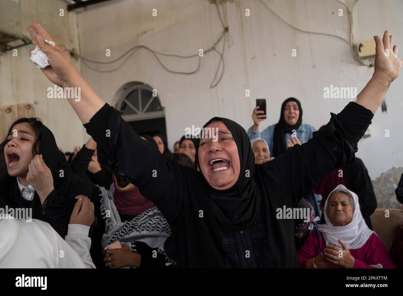 Palestinian mourners cry after taking the last look at the body of ...