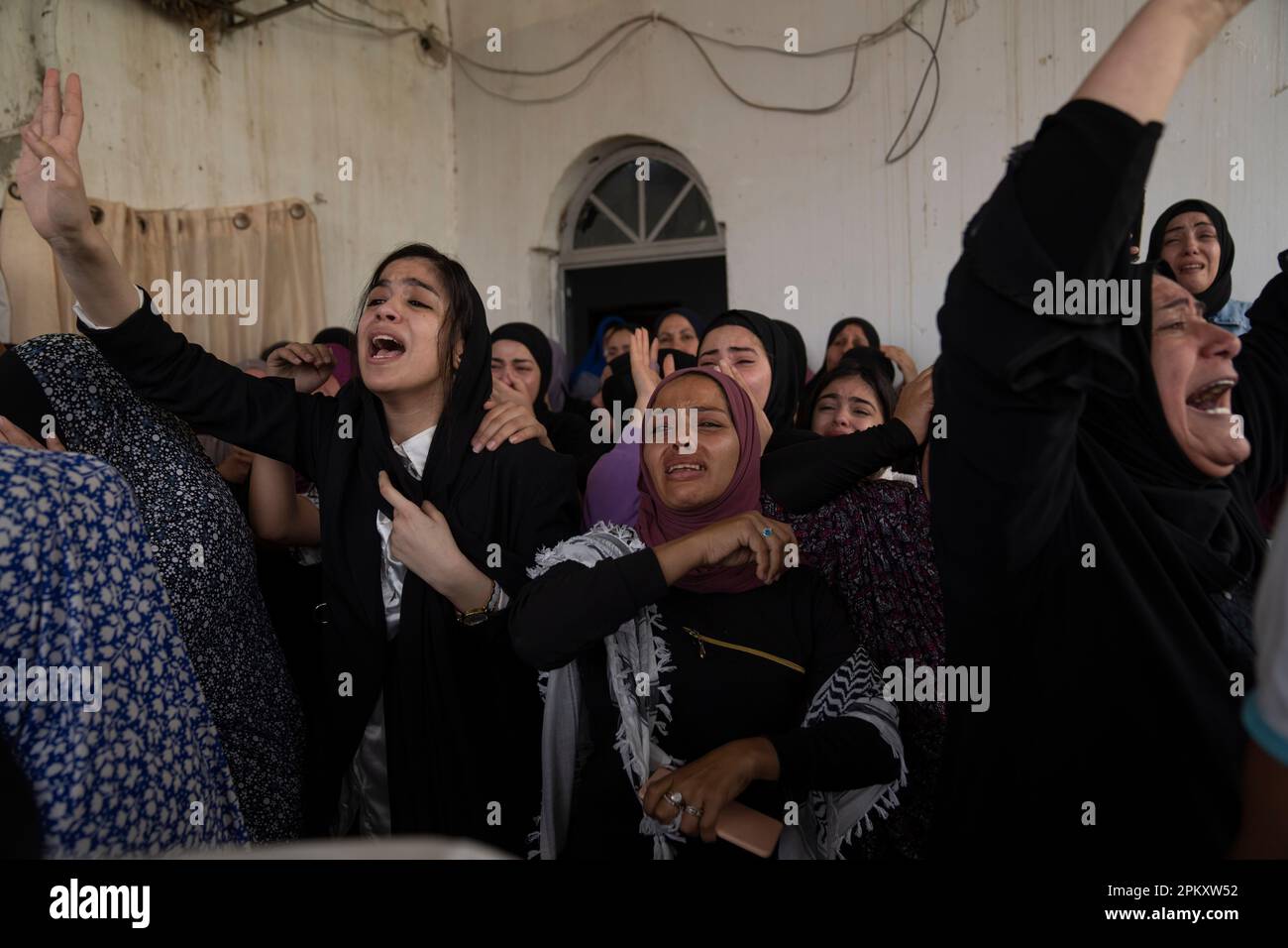 Palestinian mourners cry and react after taking the last look at the ...