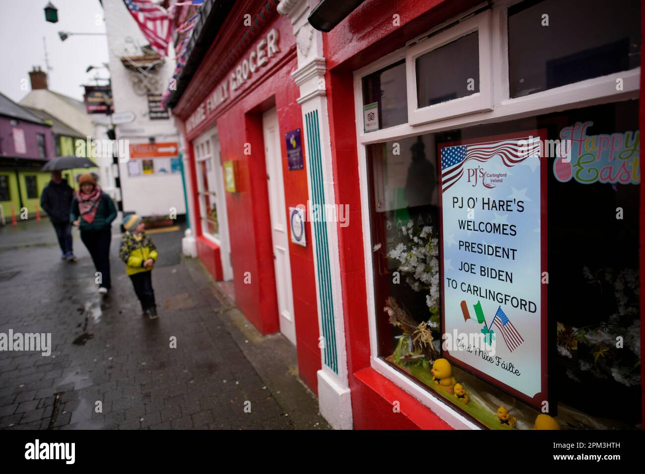 Pedestrians walk along a street in Carlingford, Ireland, Tuesday, April ...