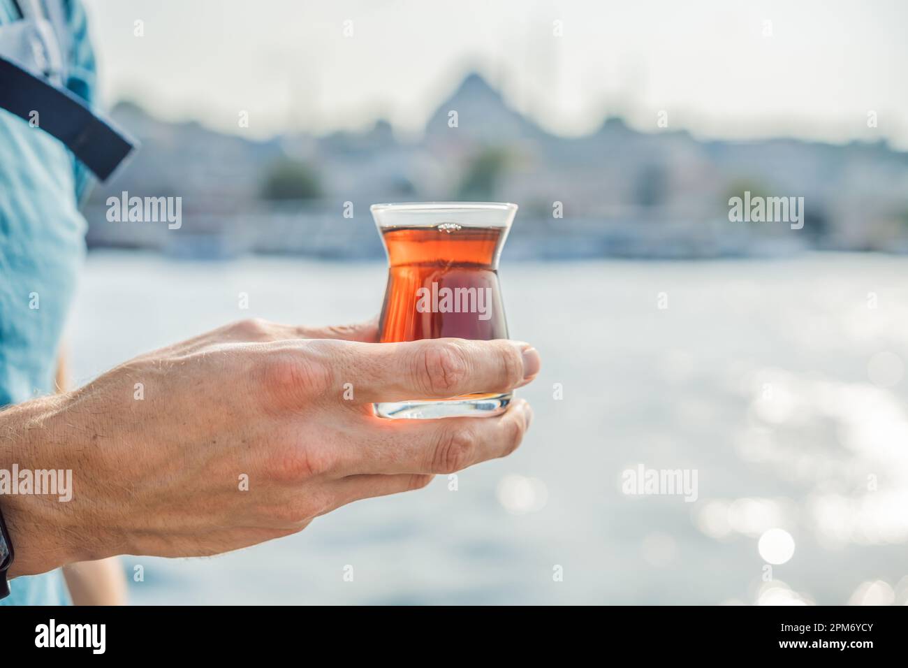Ein Mann in Istanbul frühstückt mit Simit und einem Glas türkischen Tee ...