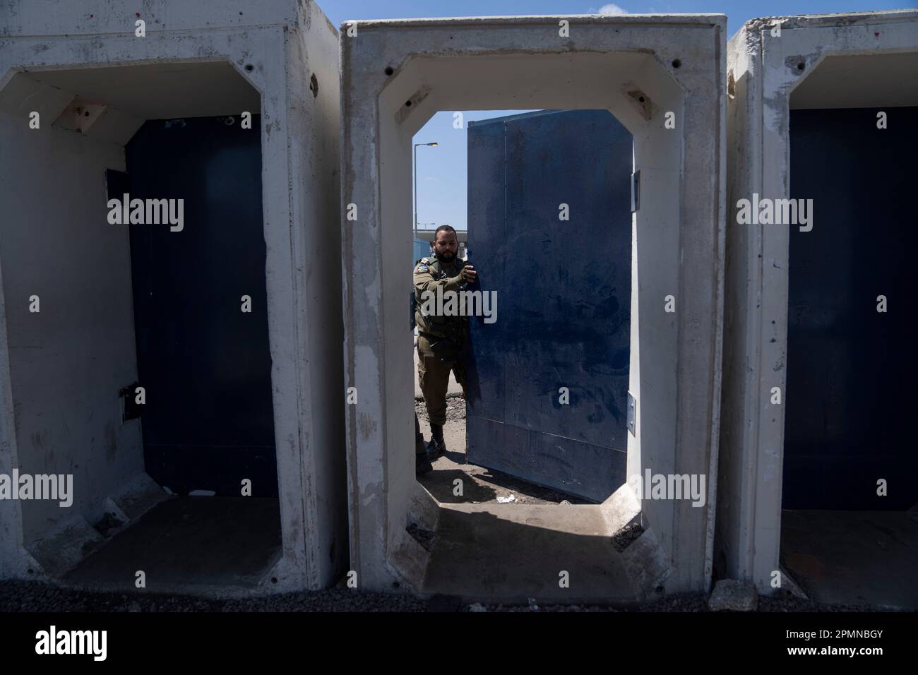 An Israeli army officer closes the gates of the checkpoint that is ...