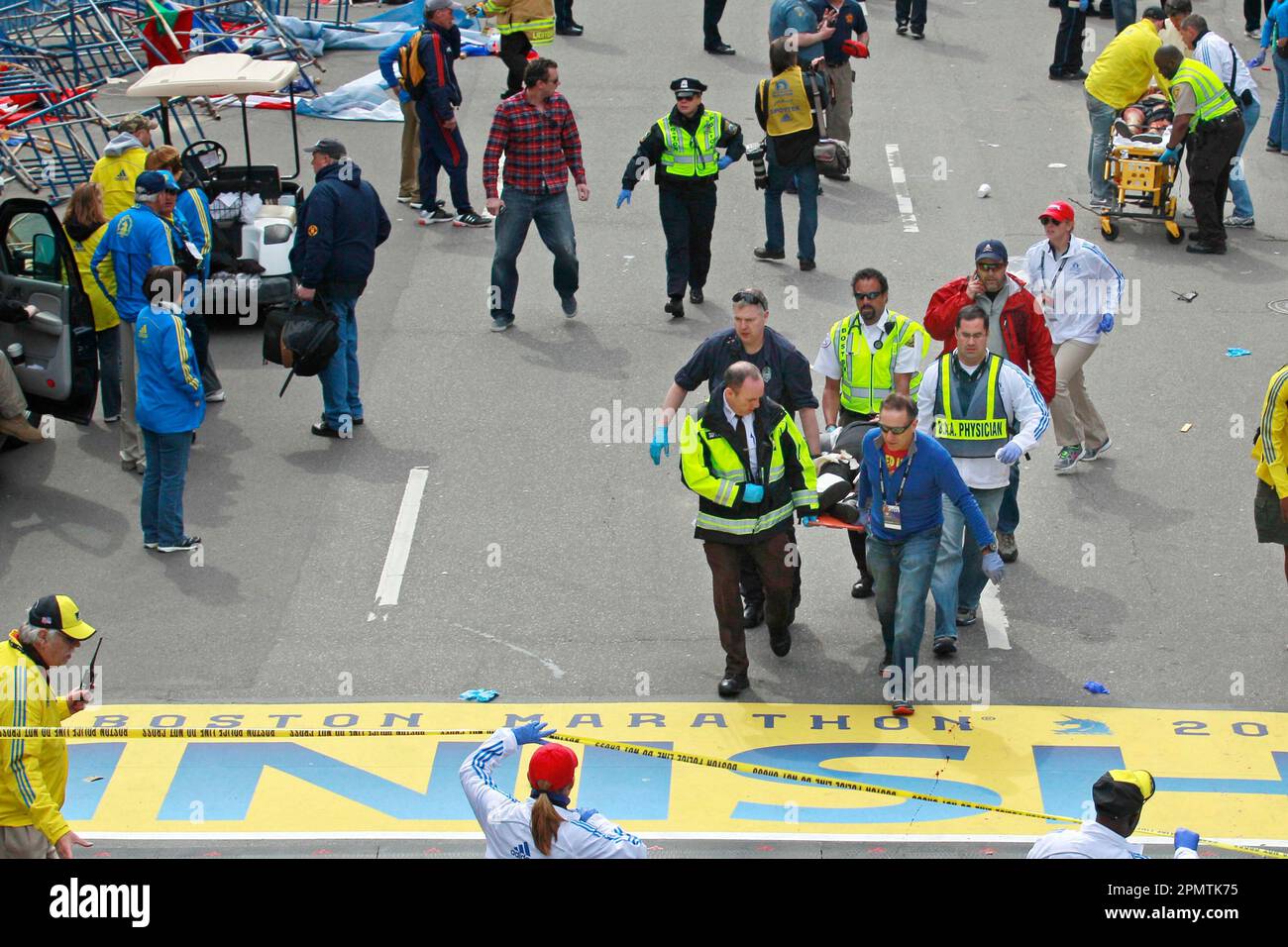 Emergency workers aid injured people at the finish line of the 2013 ...