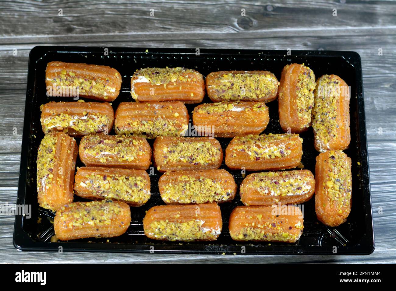 Tulumba, Bamiyeh oder Balah El Sham gefüllt mit Schlagsahne und bedeckt ...