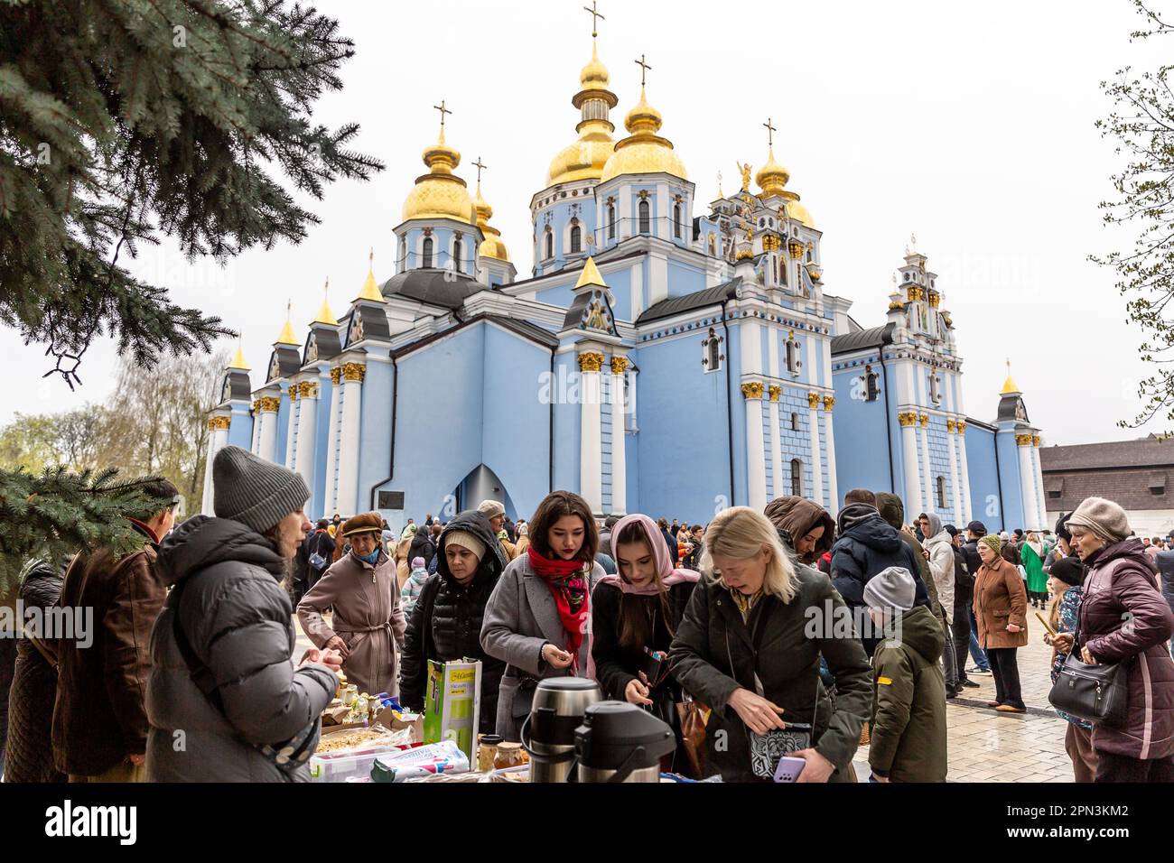 Ukrainische Frauen stehen an einem Stand mit Osterbasen, während die ...