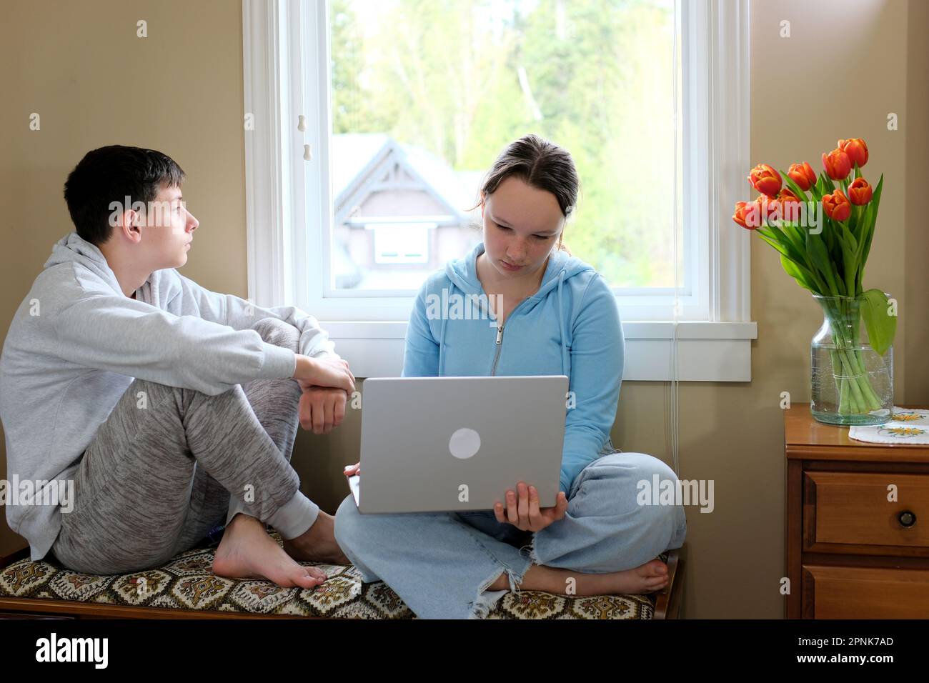 Mädchen und Junge Teenager sitzen am Fenster Mann schaut auf junge Frau ...