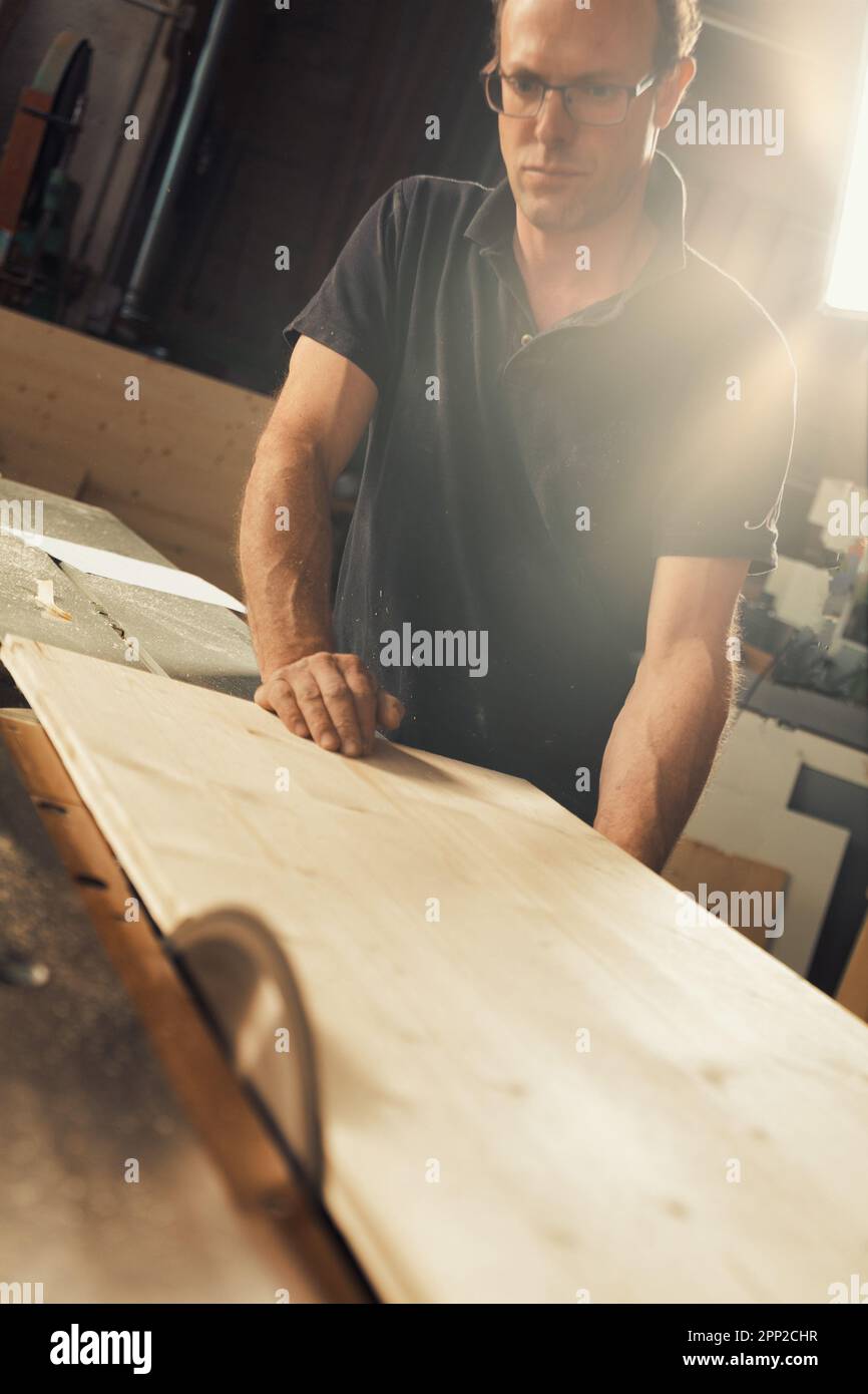 Ein Mann arbeitet mit einer Kreissäge. Er könnte Zimmermann oder ...