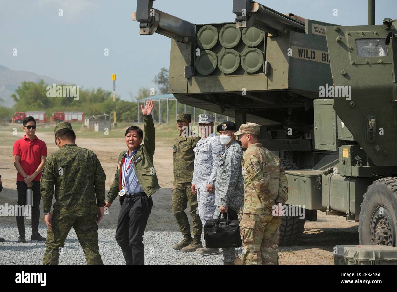 Philippine President Ferdinand Marcos Jr. waves beside a U.S. M142 High ...
