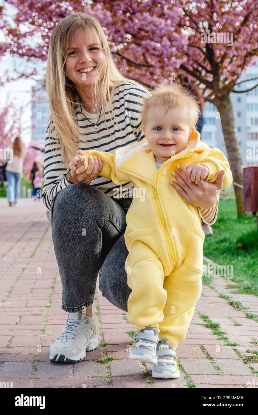 Der süße Moment einer Mutter, die ihrem Sohn hilft, seine ersten ...