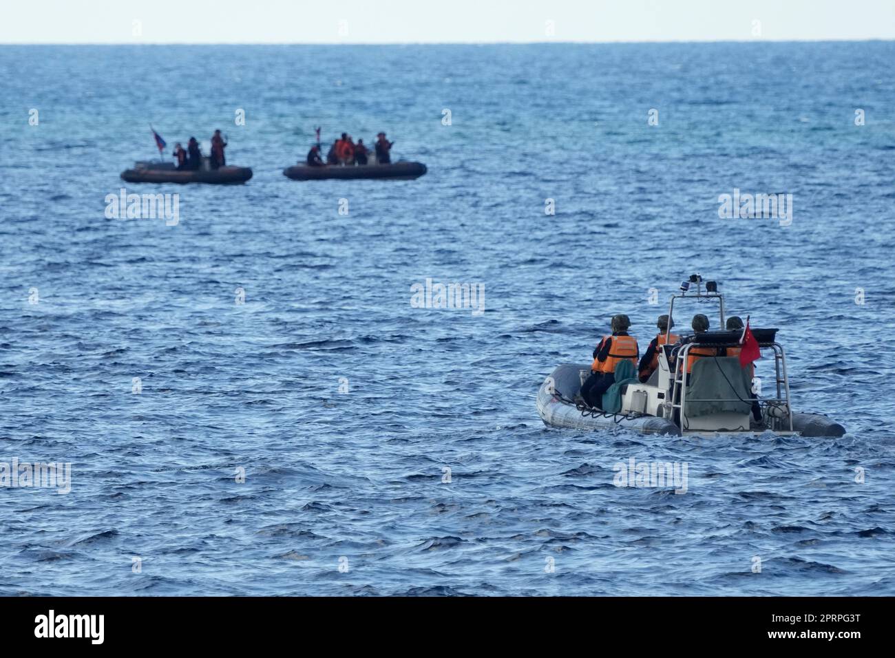 The crew of a Chinese Coast Guard ship, right, monitors activities of ...