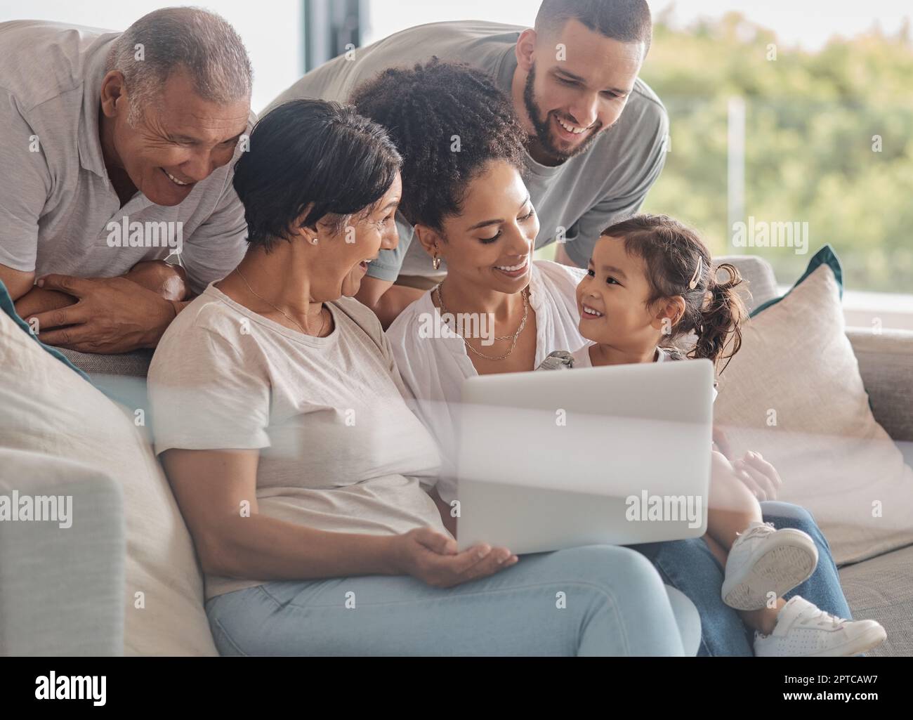 Glücklich, ein Notebook und eine große Familie streamen einen Film ...