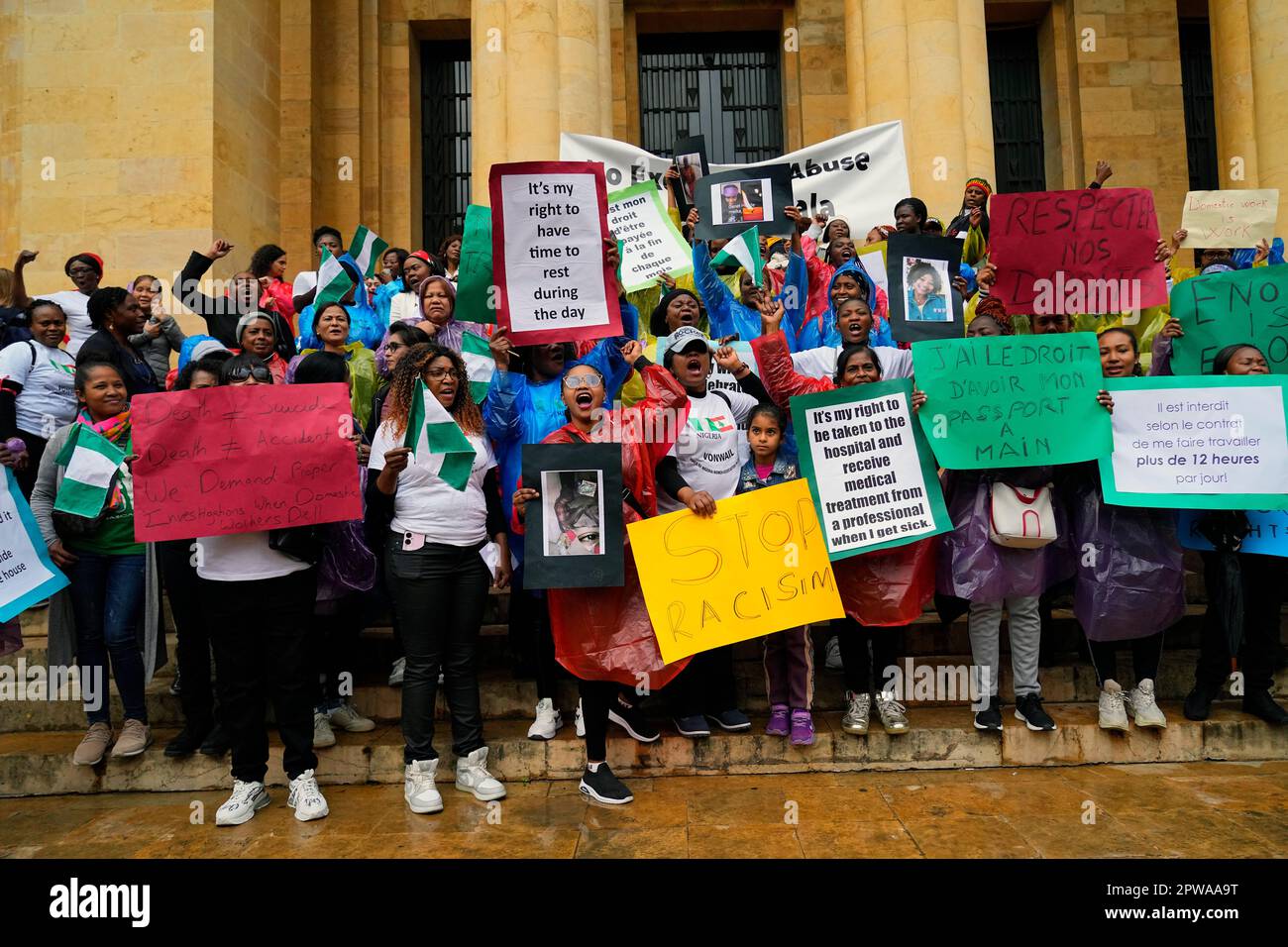 Domestic workers chant slogans as they hold placards during a protest ...