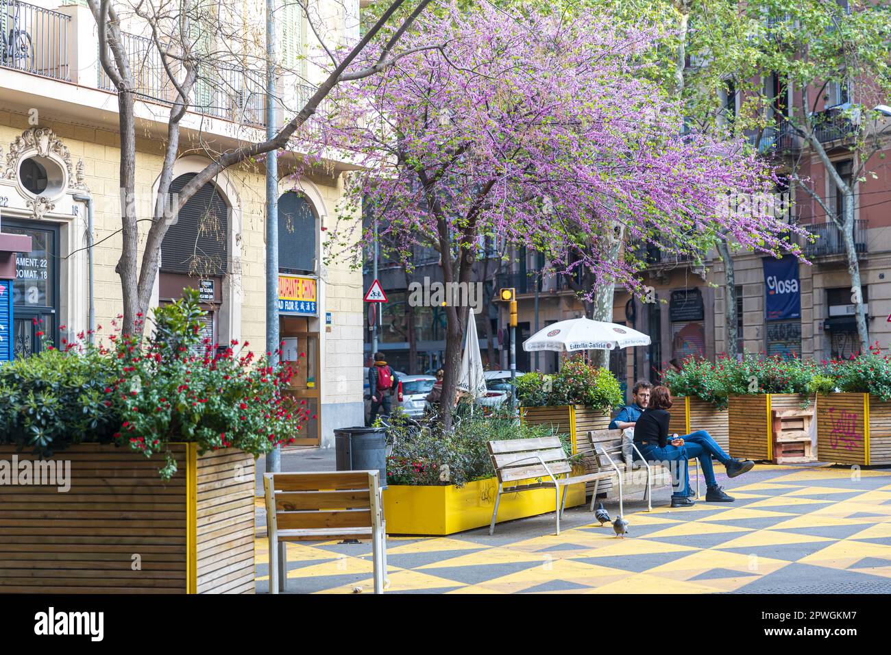 Barcelona, Spanien - 26. April 2023 sitzen Ein Mann und eine Frau auf dem Raval Square unter ...