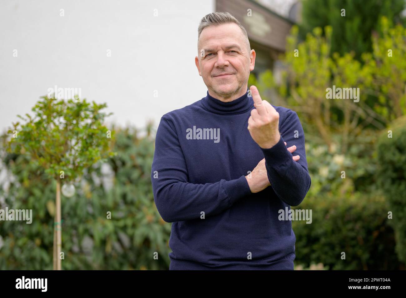 Ein Mann mittleren Alters mit grauen Haaren, unrasiert, mit blauem ...