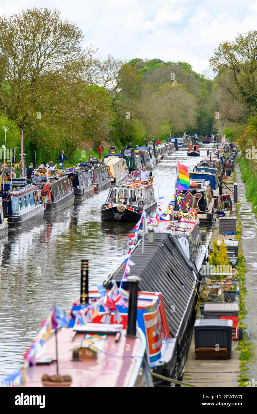 Ein Narrowboat, das zwischen festsitzenden, rotierenden Handelsbooten ...