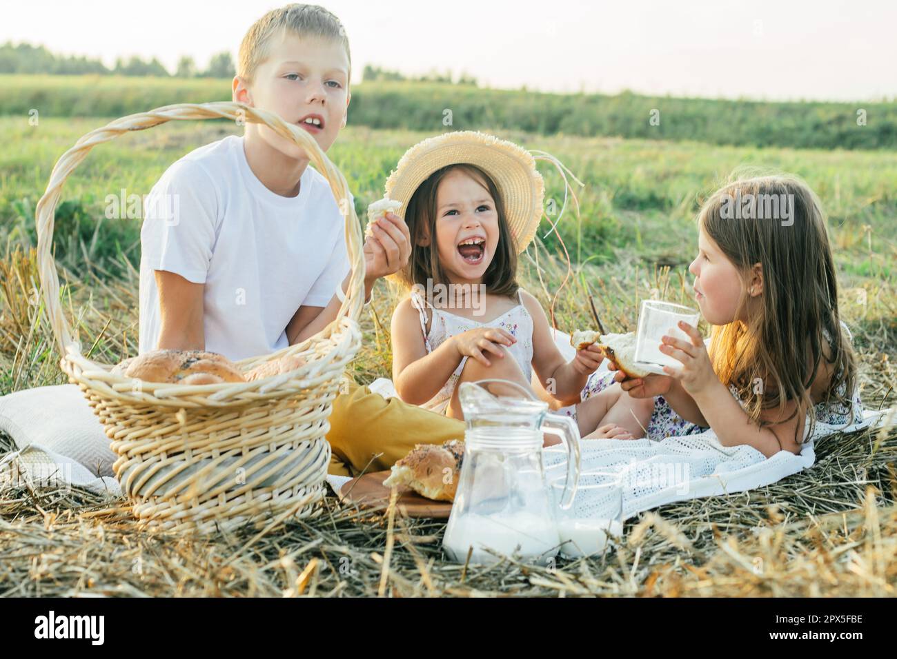 Porträt eines fröhlichen Jungen und zweier Mädchen, die auf der Decke ...