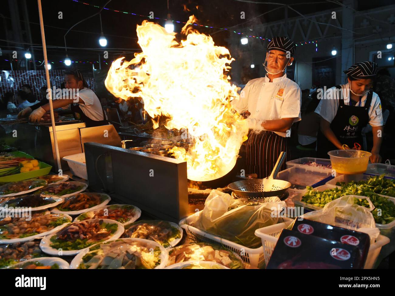TURPAN, CHINA - 1. MAI 2023 - Ein Koch kocht am Abend des 1. Mai 2023 ...