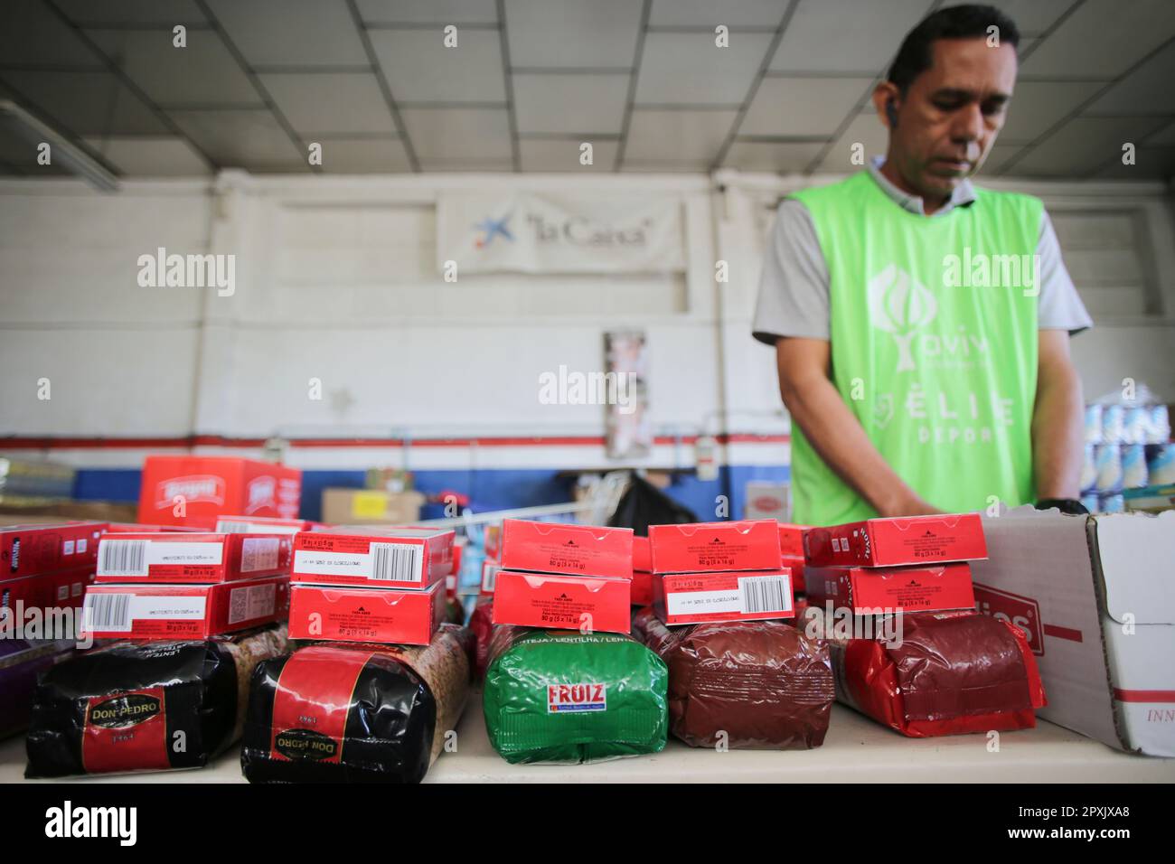Volunteers attend to people who come looking for food at the warehouse ...