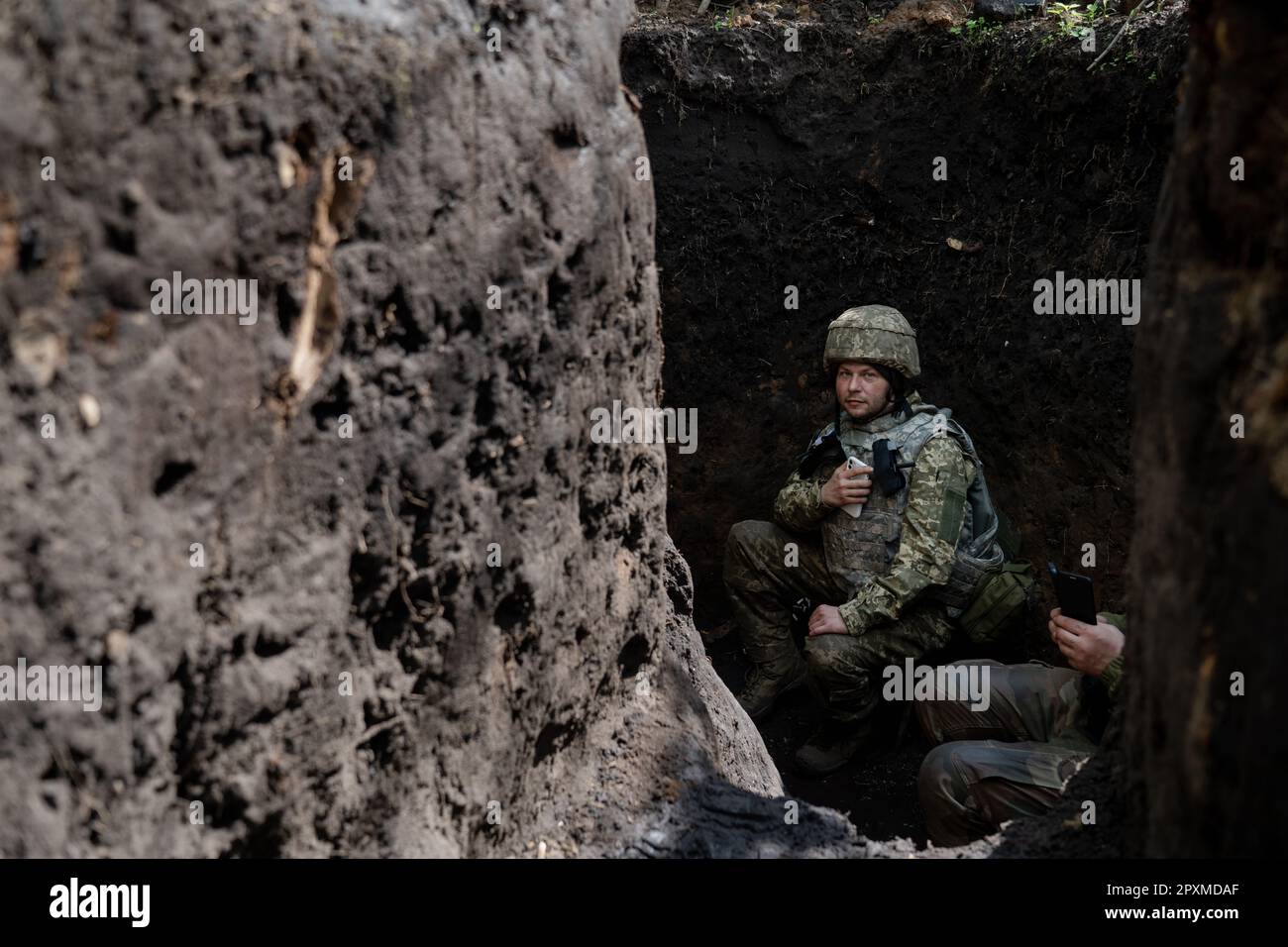 Ein ukrainischer Soldat wird im Graben mit seinem Handy gesehen, 1 km von russischer Position in ...