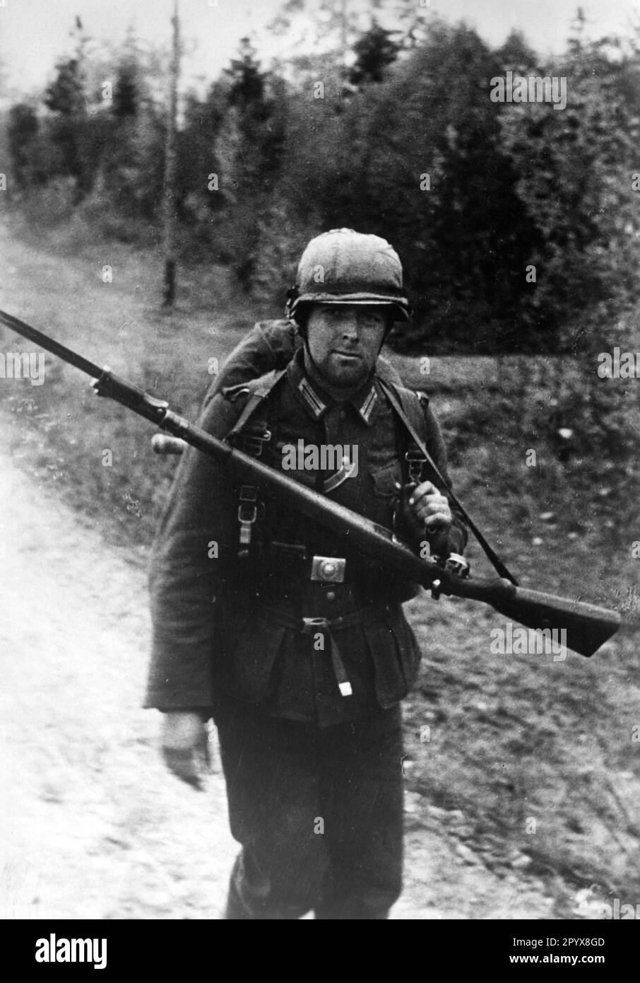 Ein Infanterist auf dem marsch an der Ostfront. Um seinen Hals trägt er ...