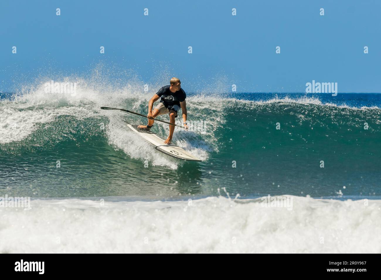 Stand-Up-Paddleboarder Surfen auf dem Gesicht einer Welle an diesem ...