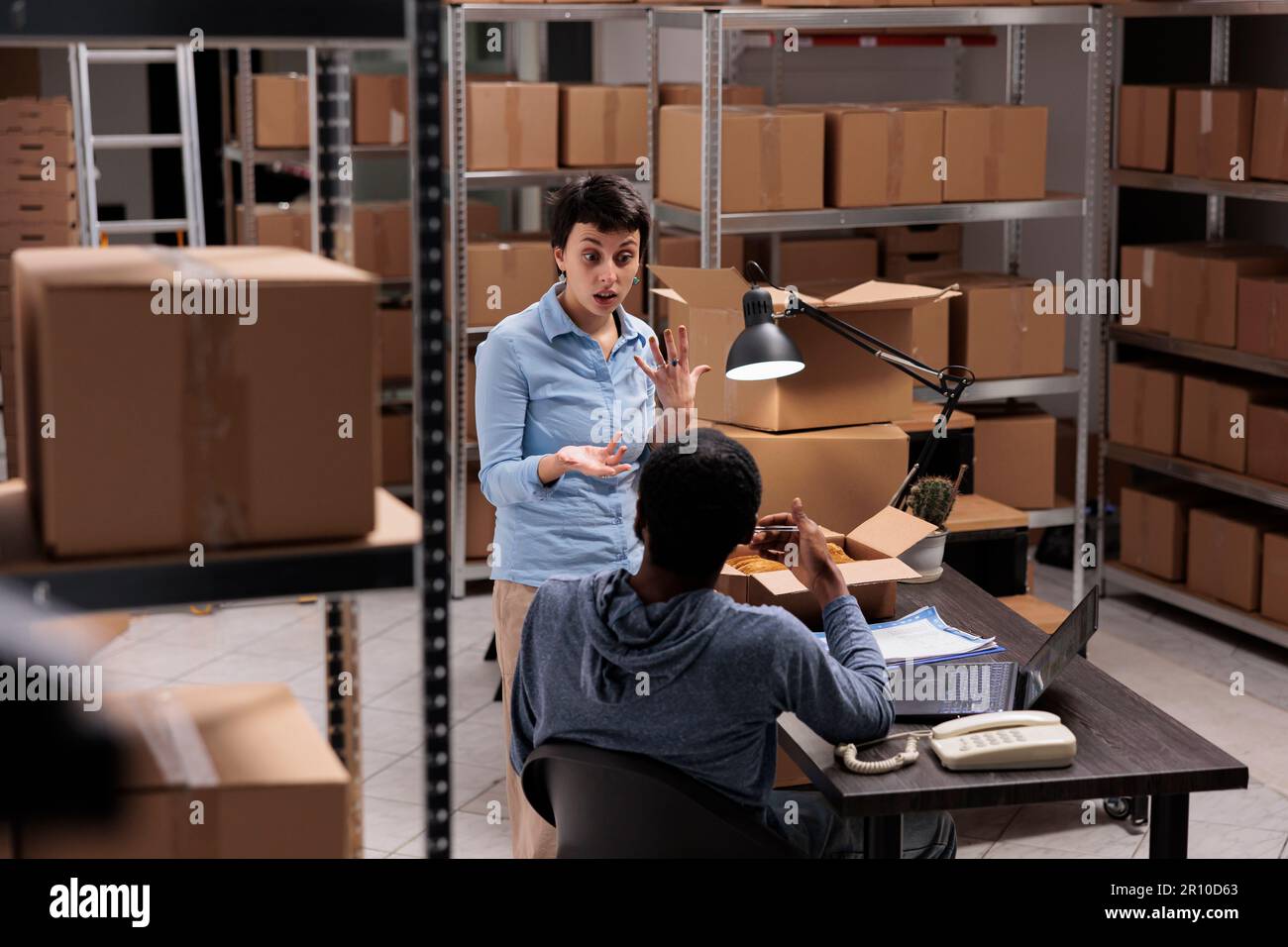 Verschiedene Lagermitarbeiter diskutieren Logistikprobleme bei der Vorbereitung von ...