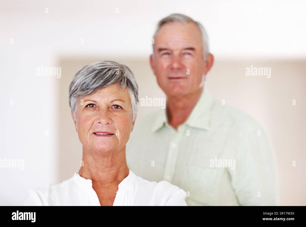 Selbstbewusste reife Frau mit Mann im Hintergrund. Porträt einer ... Selbstbewusste reife Frau mit Mann im Hintergrund. Porträt einer ...