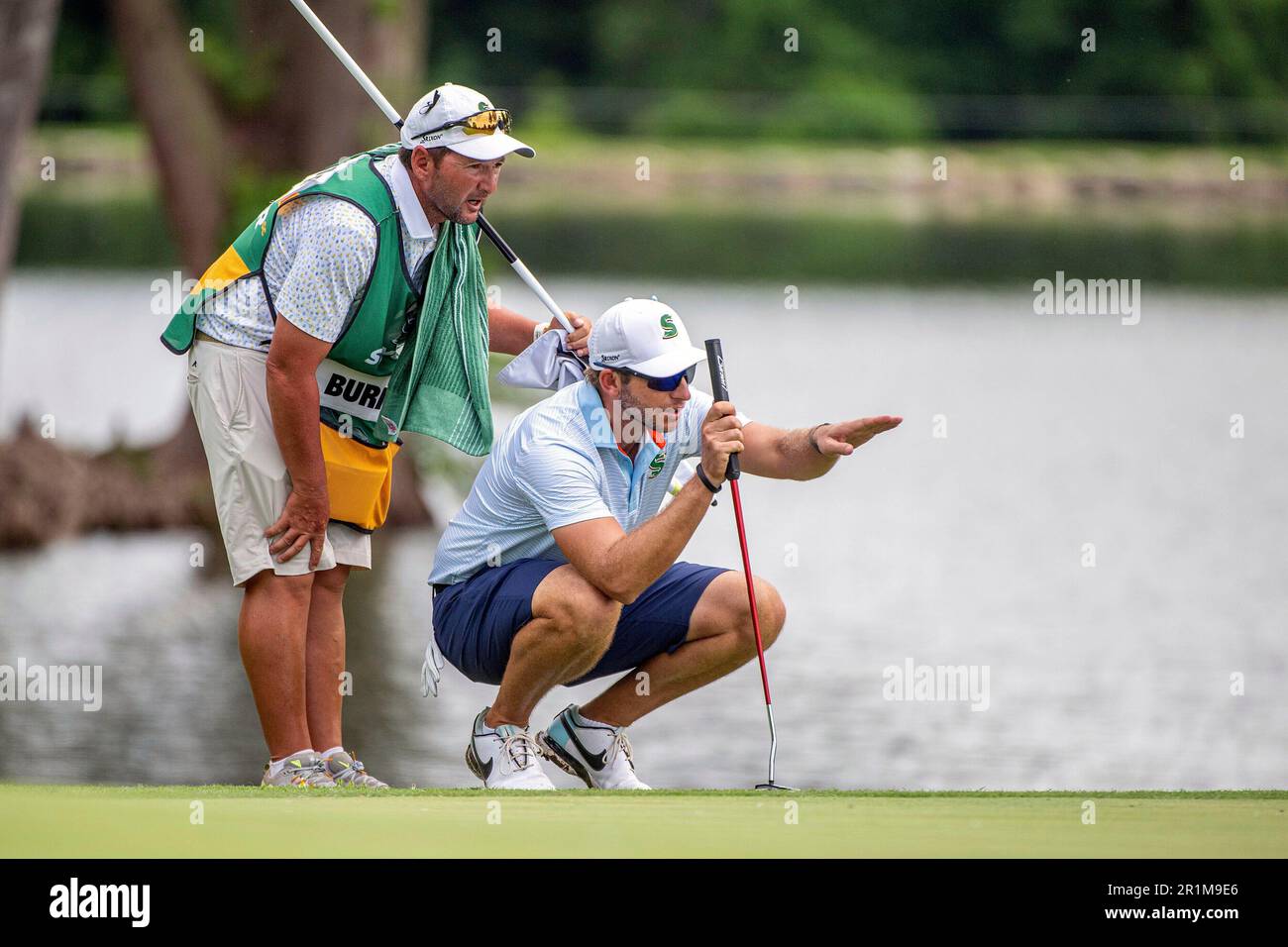 Dean Burmester, right, of Stinger GC, and his caddie line up a putt on ...