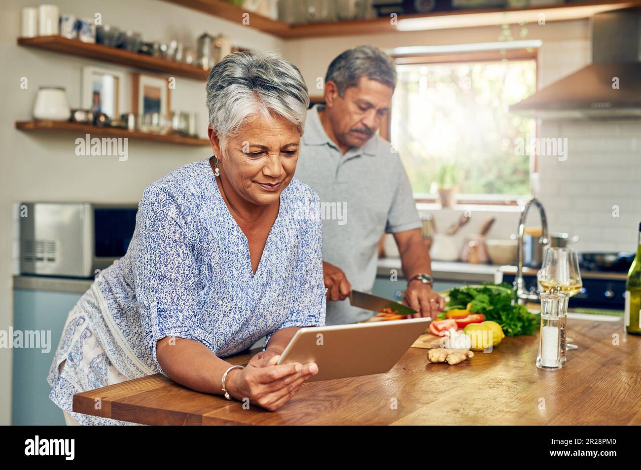 Seniorin an Küchentheke mit Mann, Tablet und Kochen gesundes Essen ...