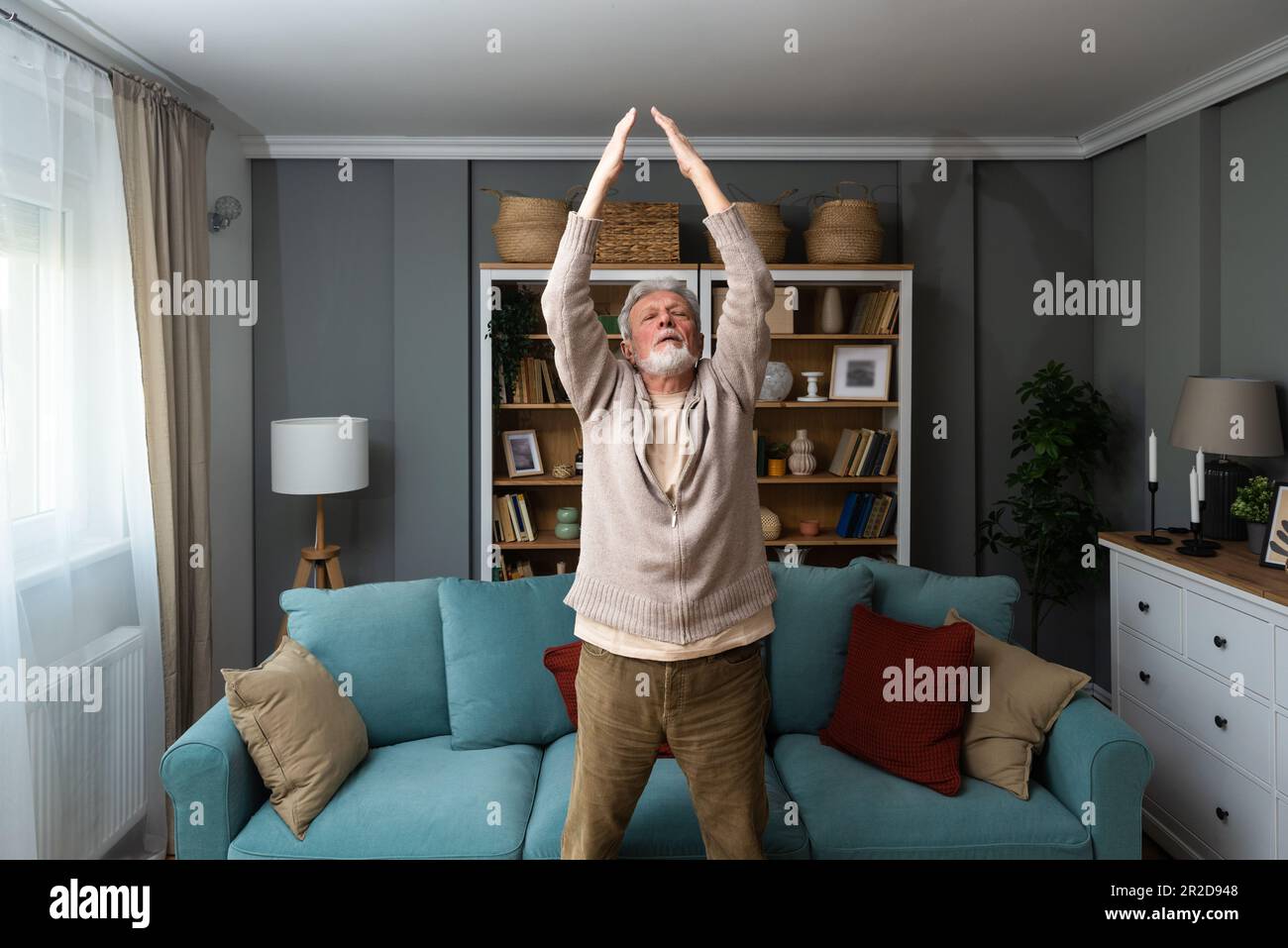 Sportlicher alter Typ, der im Haus Yoga praktiziert. Senior-Mann, der ...