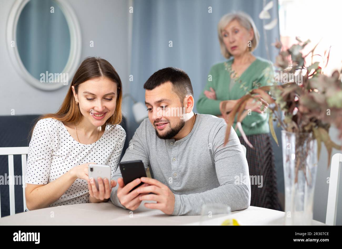 Ehemann und Ehefrau zeigen sich gegenseitig Fotos auf dem Smartphone ...