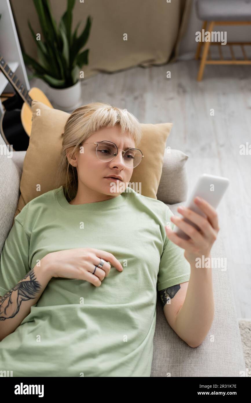 Blick von oben auf eine junge Frau mit Tattoo, blondem und kurzem Haar ...