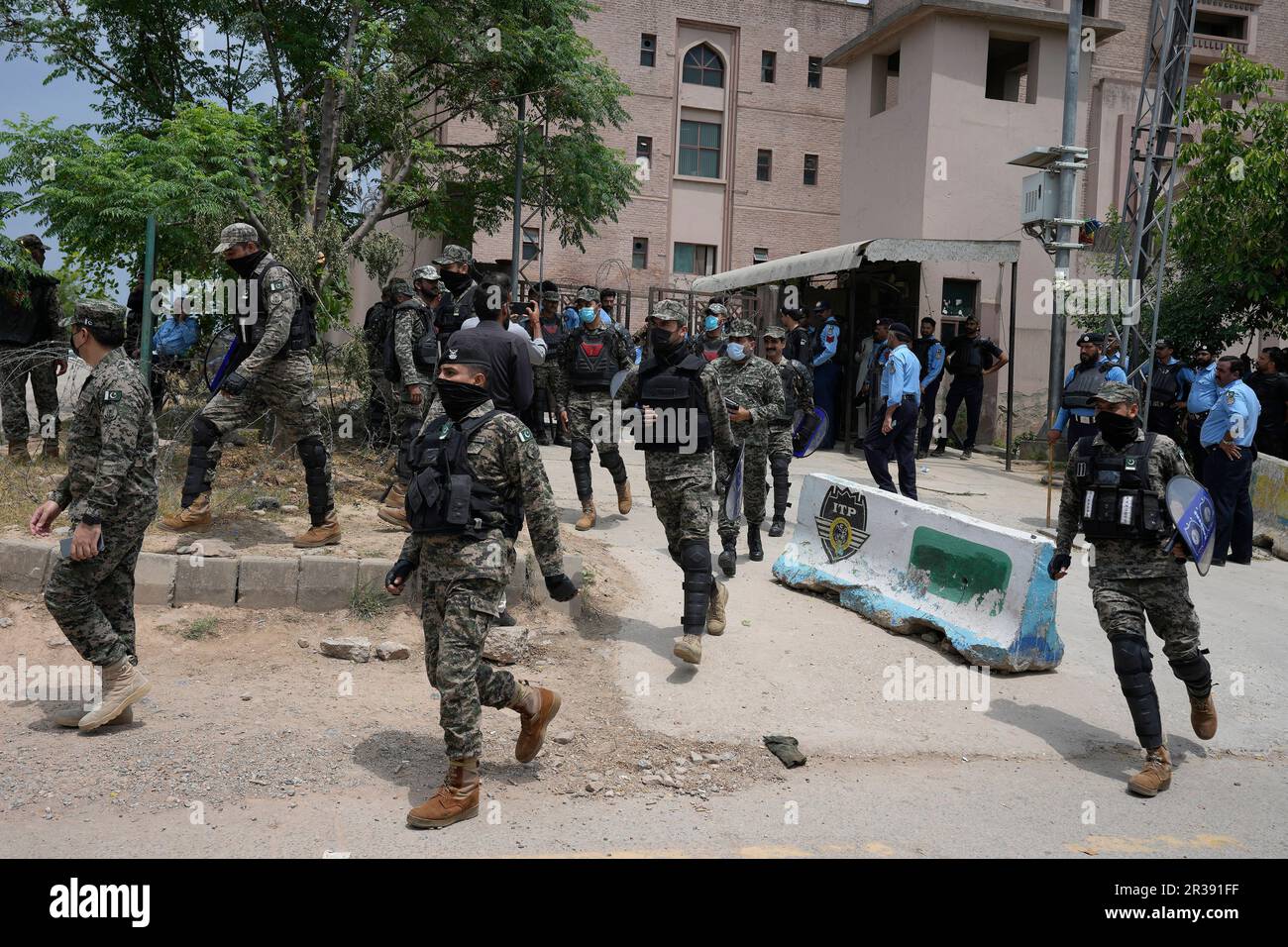 Paramilitary troops and police officers stand guard outside a court ...