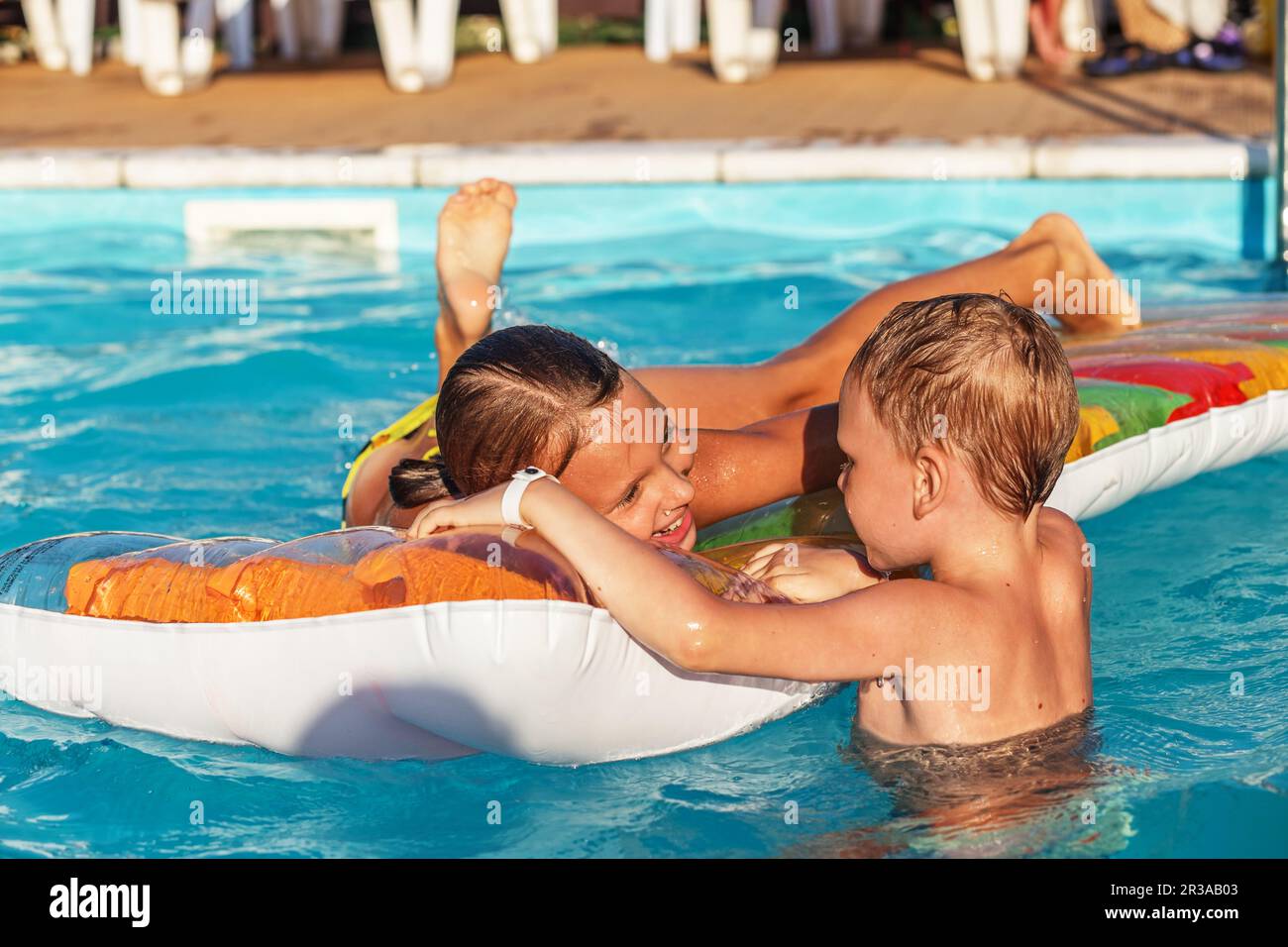 Kleine Kinder auf aufblasbarer Matratze im Pool. Lächelnde Kinder spielen und Spaß haben im Pool ...