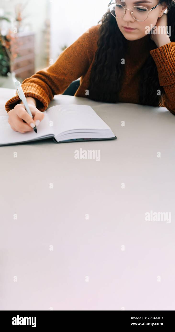 Frau, die im Copybook schreibt. Geschäftsfrau oder junge Studentin, die ...
