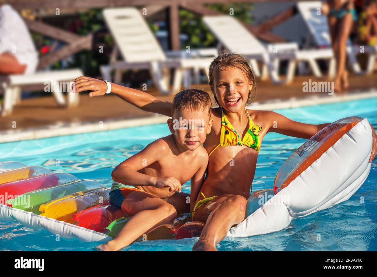 Kleine Kinder auf aufblasbarer Matratze im Schwimmbad. Lächelnde Kinder spielen und Spaß haben ...