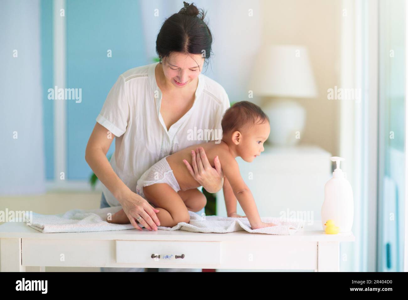 Mutter wechselt die Windel beim Neugeborenen. Mama und lachender Junge ...