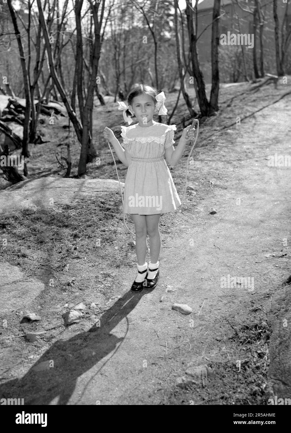 In den 1950er Jahren. Ein Mädchen in einem schönen Kleid springt über ...