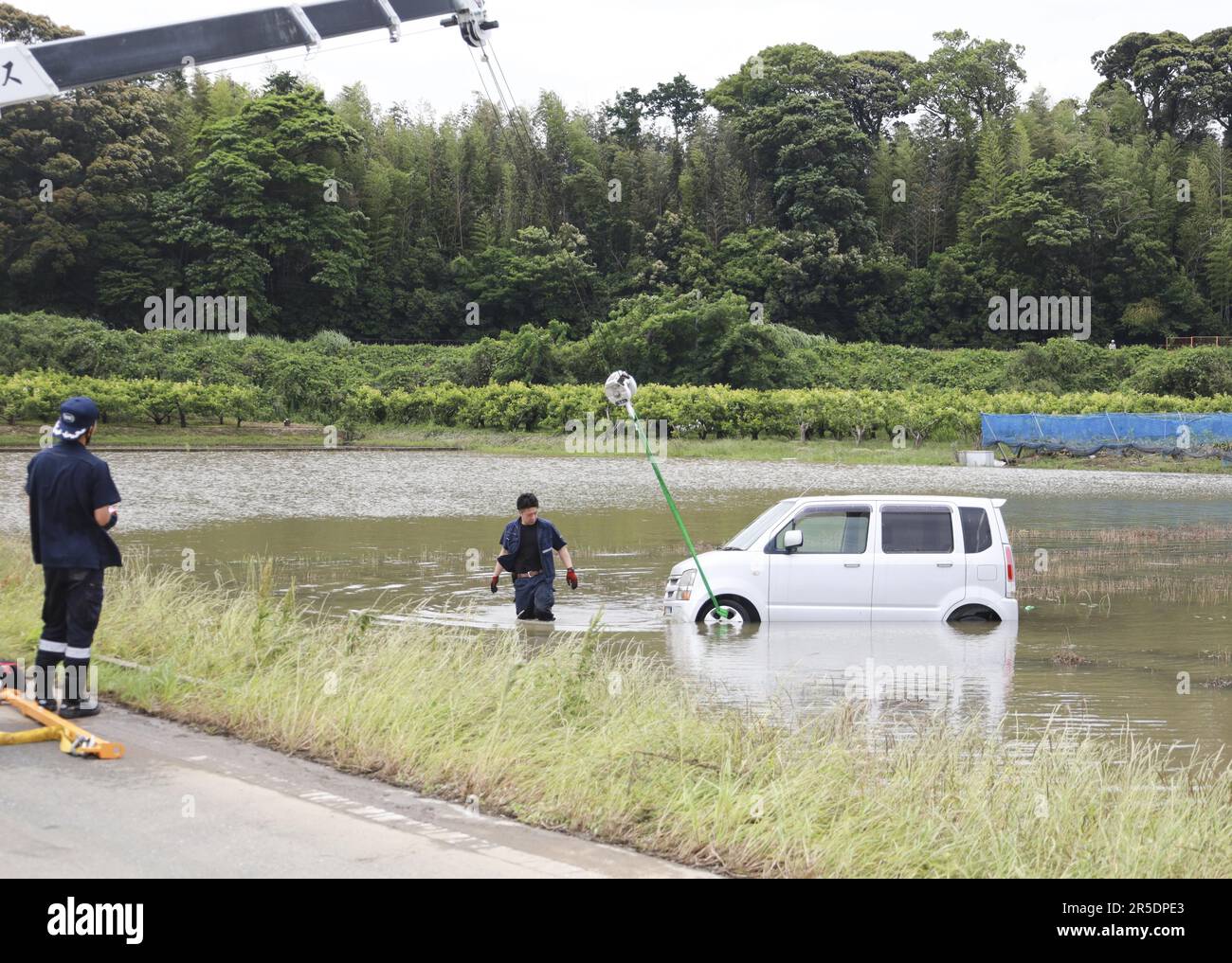 Am 3. Juni 2023 schleppte ein Kran ein Auto aus einem überfluteten Feld in der Präfektur Aichi ...