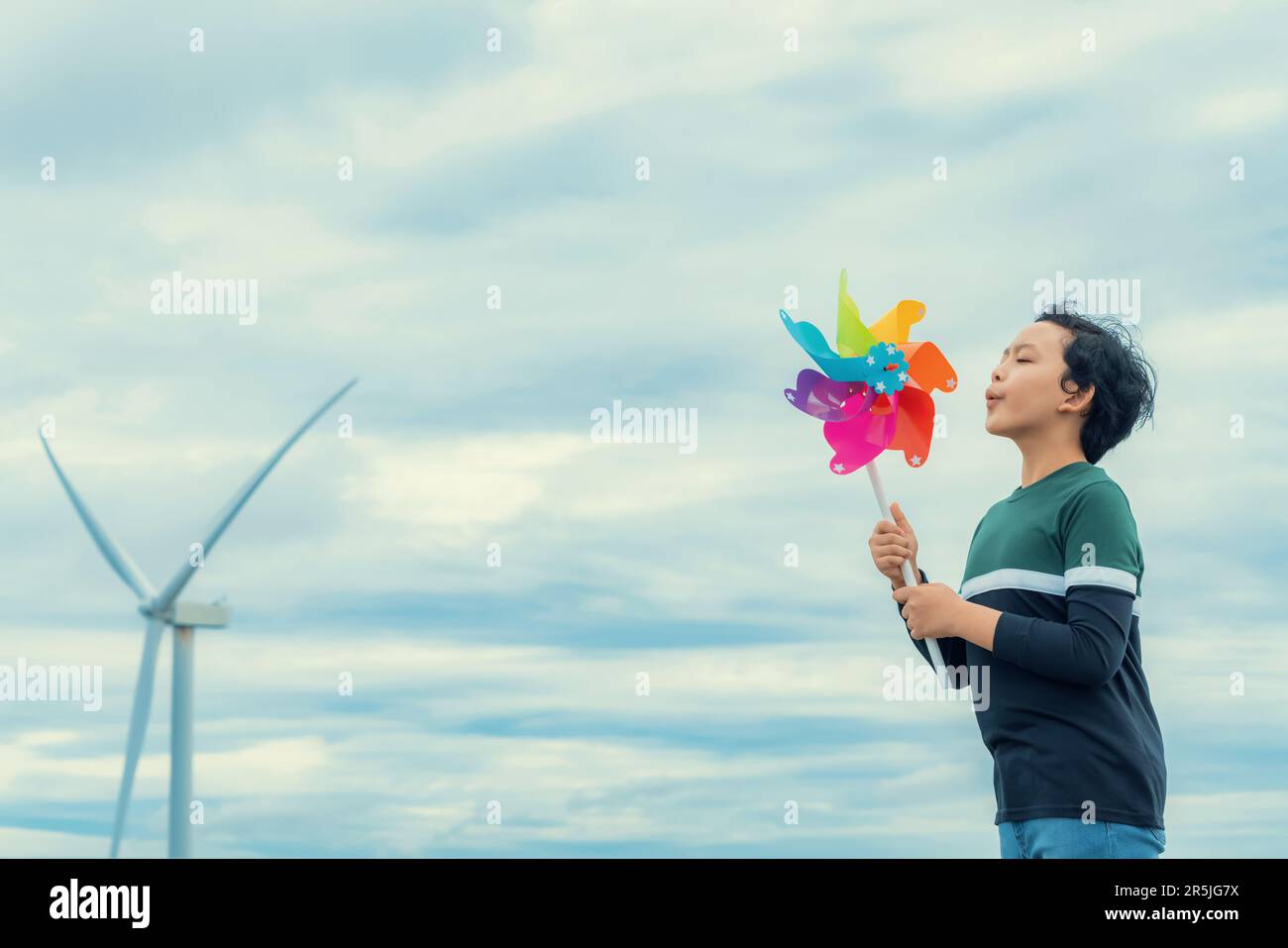 Progressiver junger asiatischer Junge, der mit dem Windrad spielt, auf ...