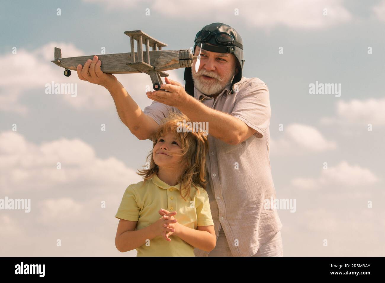 Großvater und Enkel haben Spaß mit dem Spielzeugflugzeug am Himmel ...