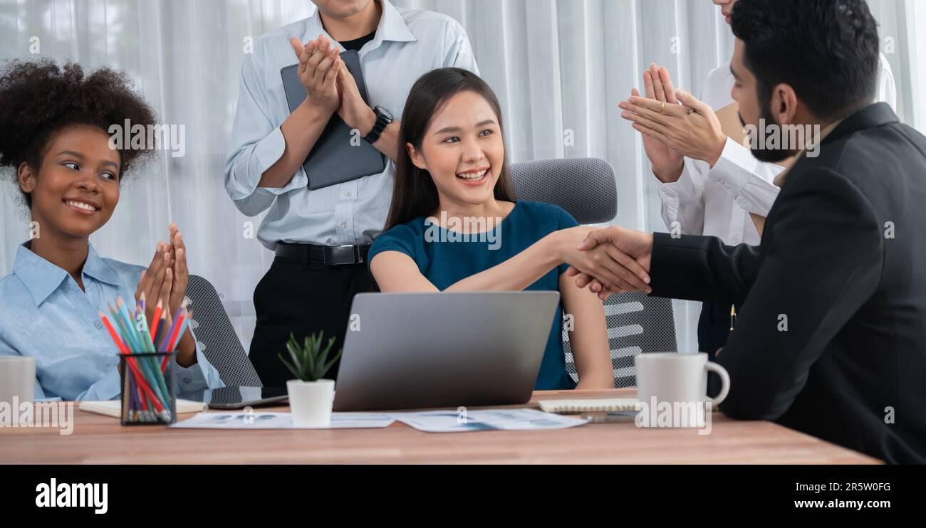 Vielfältige Kollegen feiern den Erfolg mit Handschlag und Teamarbeit am ...