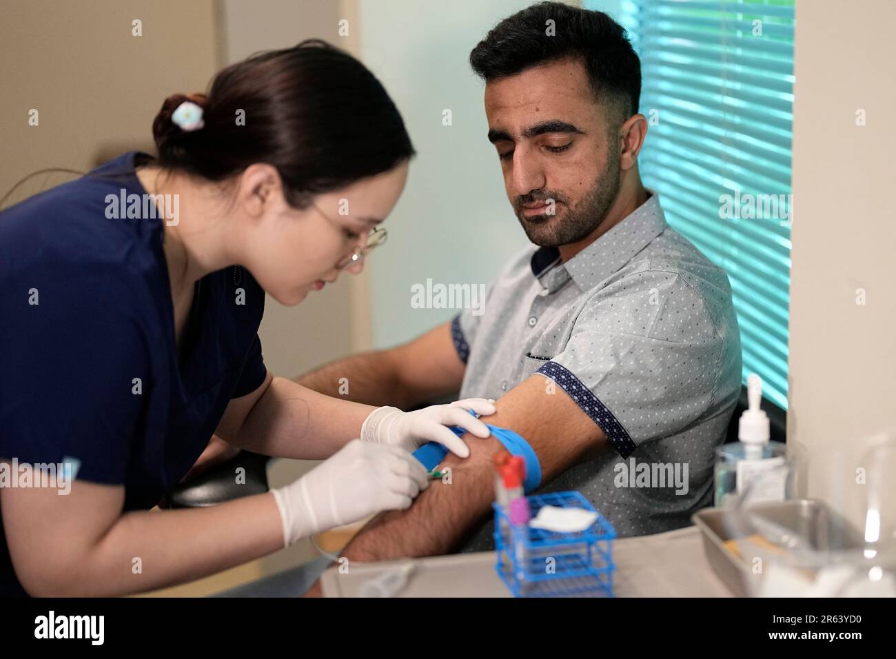 Abdul Wasi Safi, right, has his blood drawn by Bianca Gonzalez during a ...