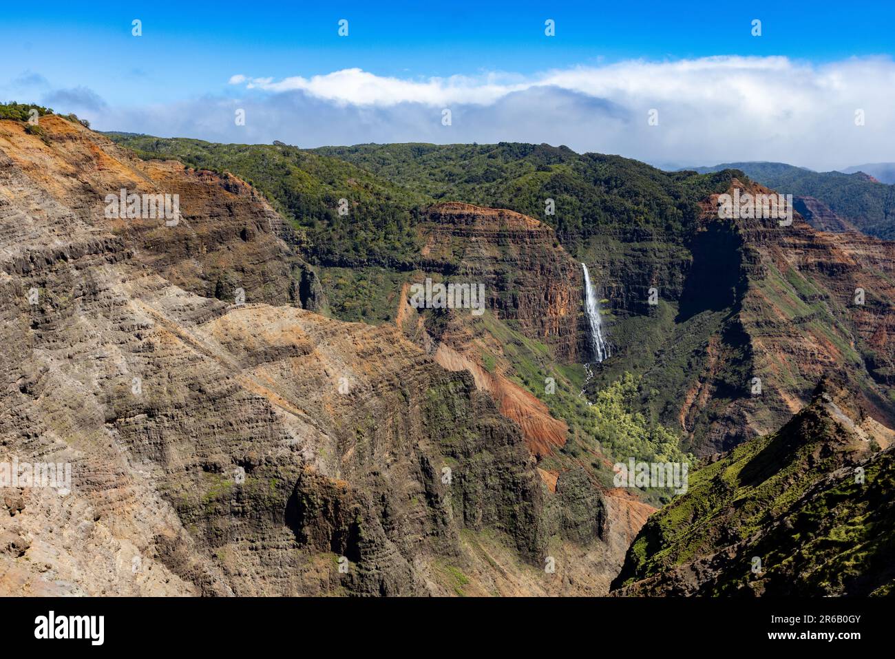 Ein Wasserfall in grünen Bergen im Waimea Canyon State Park in Kauai ...